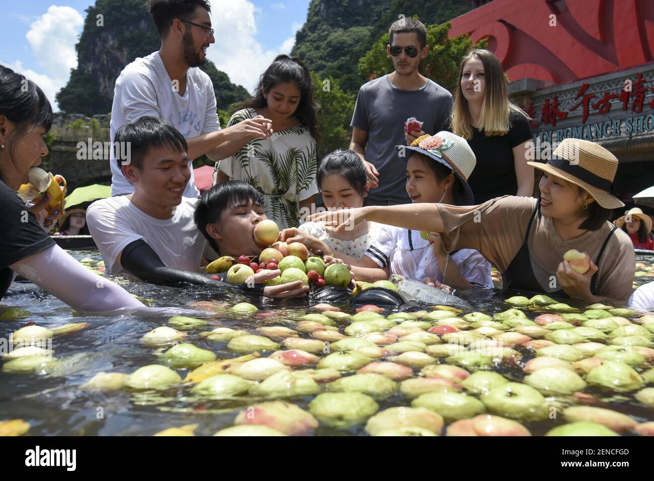 Tourists enjoy iced fruits in an ice-bucket to cool off at the Guilin ...