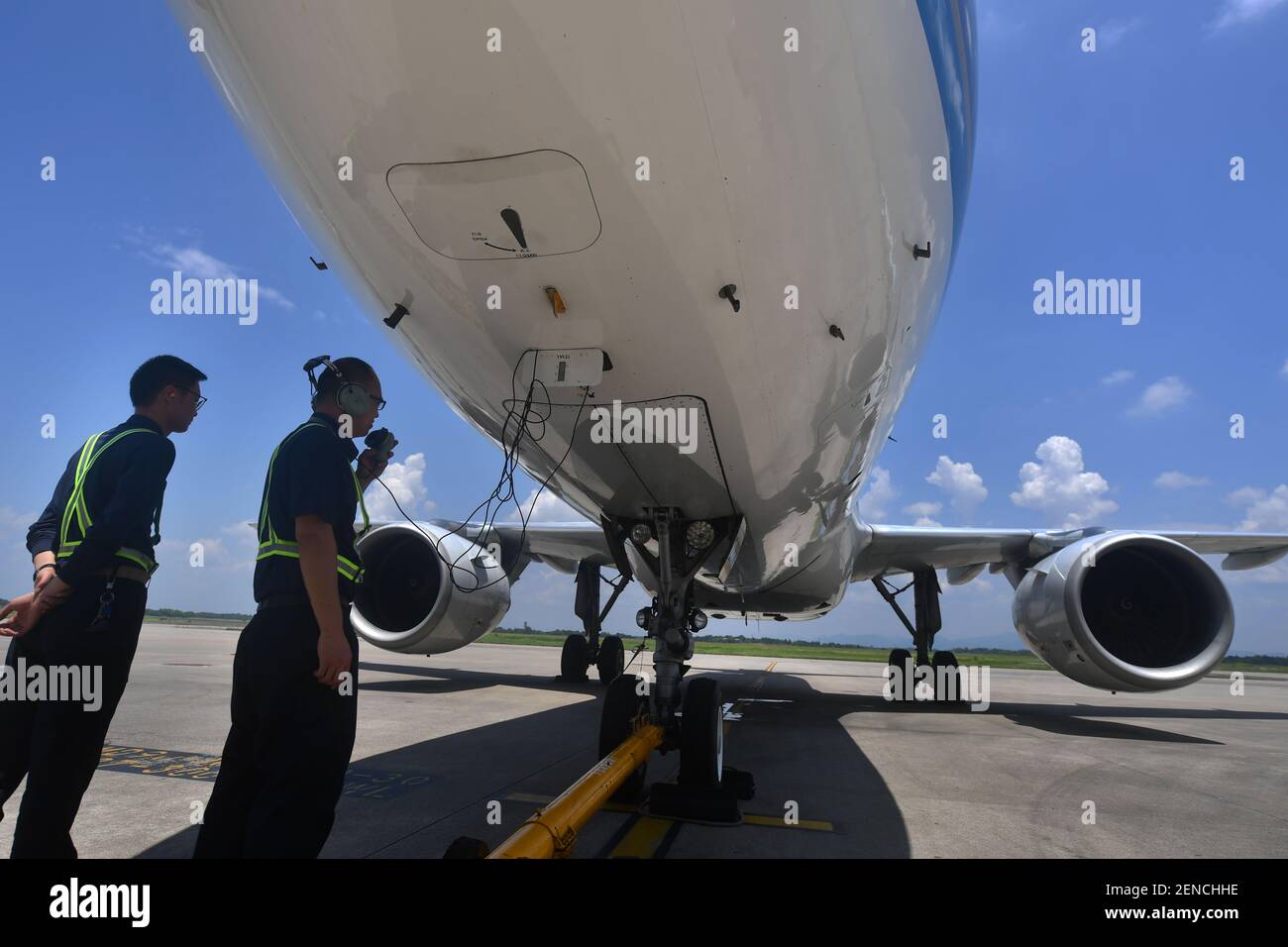 Chinese ground crew members check a jet plane at the Changsha Huanghua ...