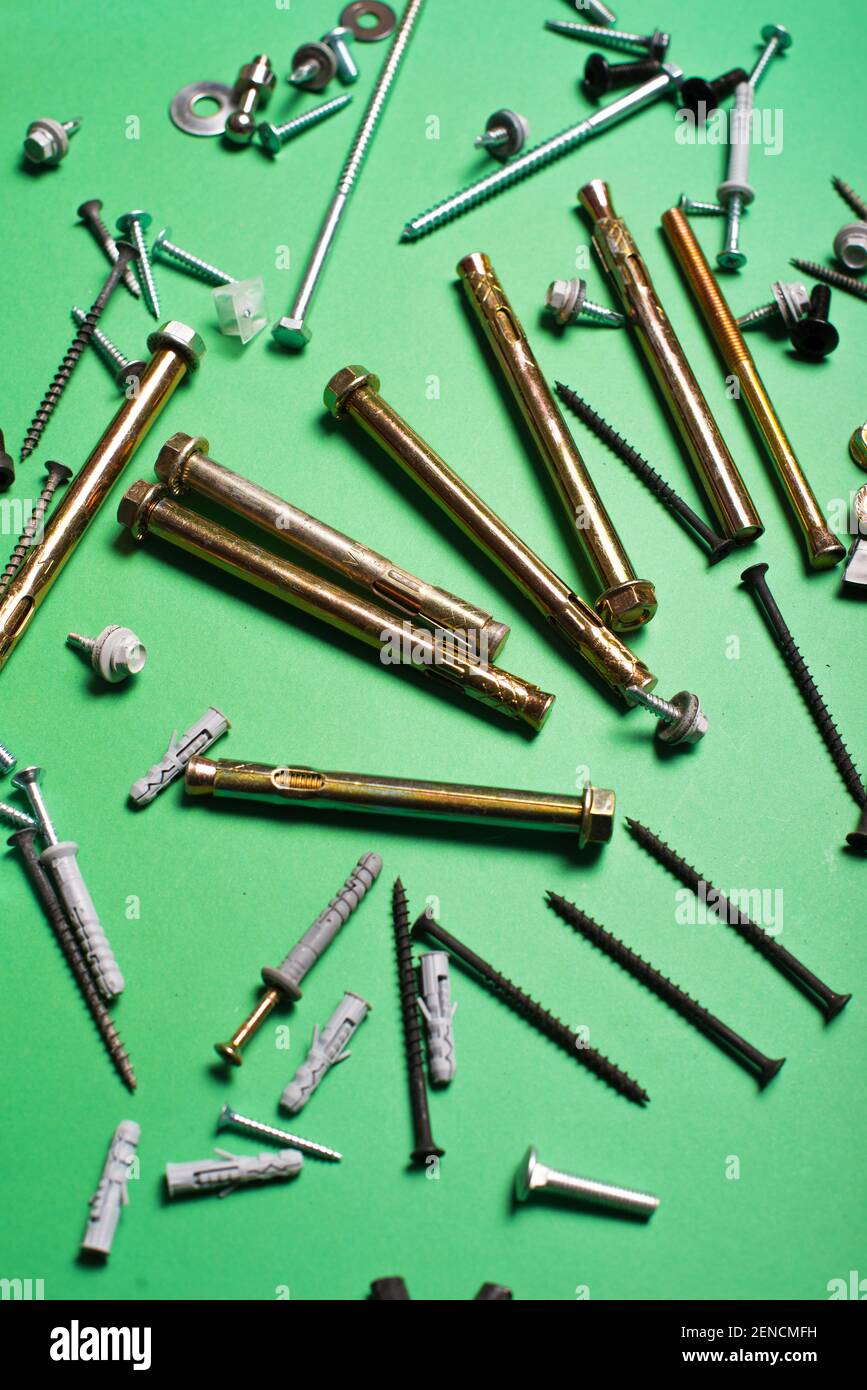Photo of different types of screws over green background Stock Photo ...