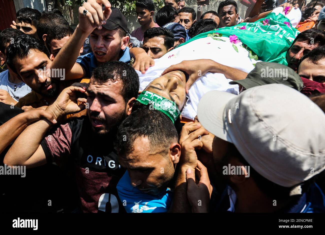 Mourners carry the body of Ahmed al-Qarra, 23, during his funeral in ...