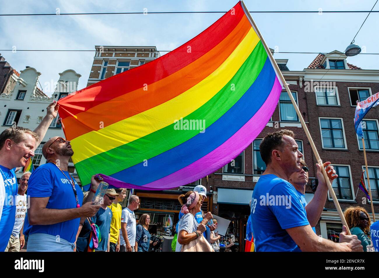 A group of men holding a rainbow-flag during the Pride Walk. Because of ...