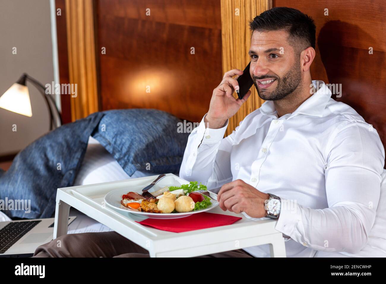 Handsome man relaxing in bed while on vacation Stock Photo - Alamy