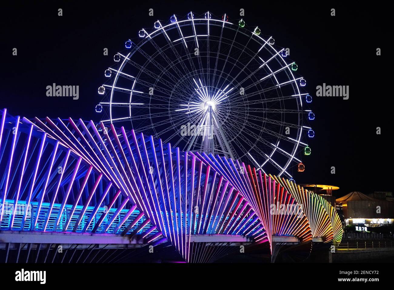 Local residents walk on the Rainbow Bridge illuminated by colorful ...