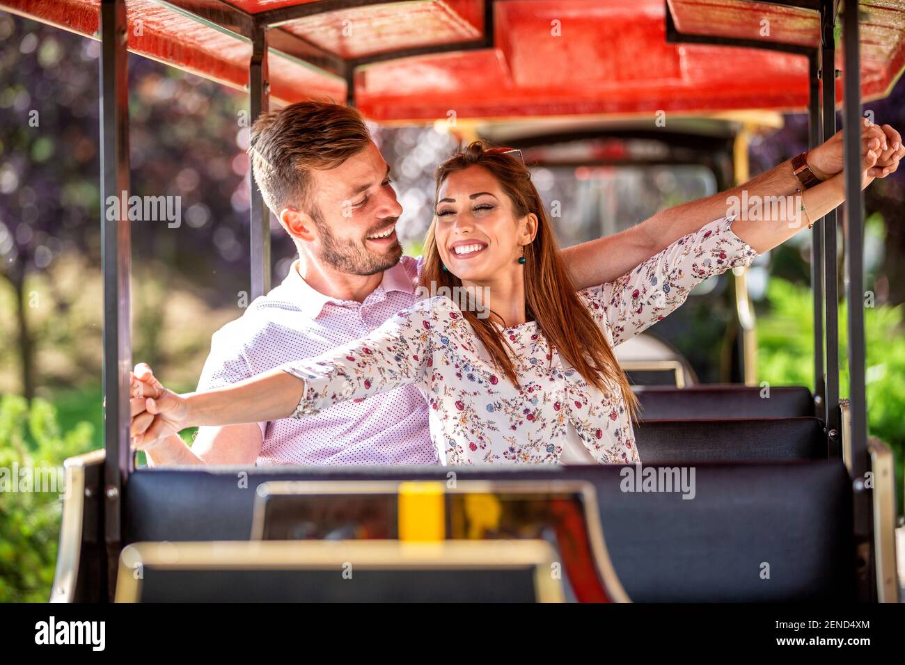 Young couple sharing unforgettable moments during a mini train ride ...