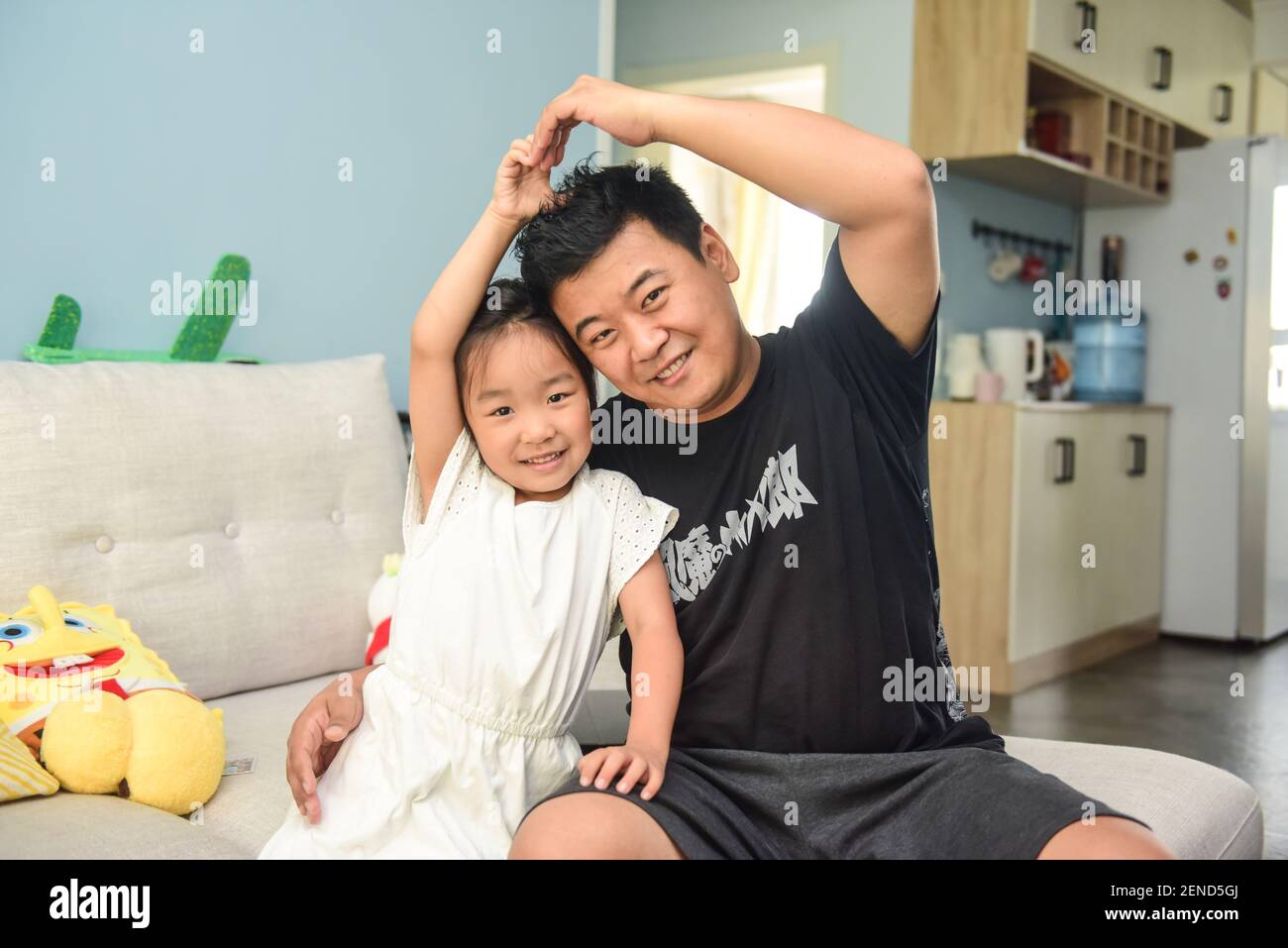 Chinese cartoonist Cheng Peng and his daughter pose for photos at home ...