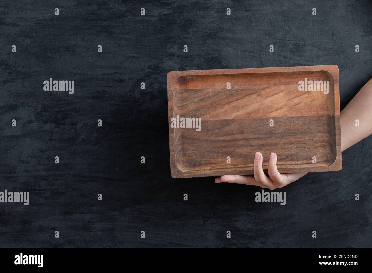 Holding a square wooden platter in the hand Stock Photo - Alamy
