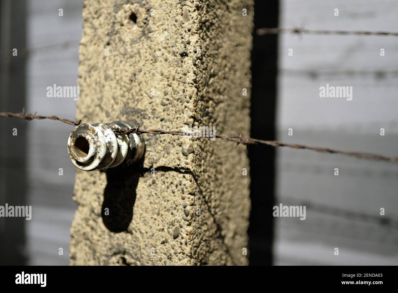 A concrete post, isolator and barbed wire that was once part of ...
