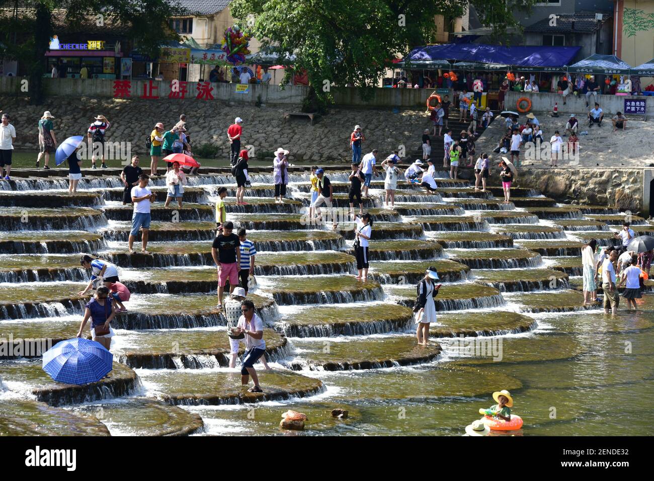 Visitors take a dip to cool off in water in a location known for fish ...