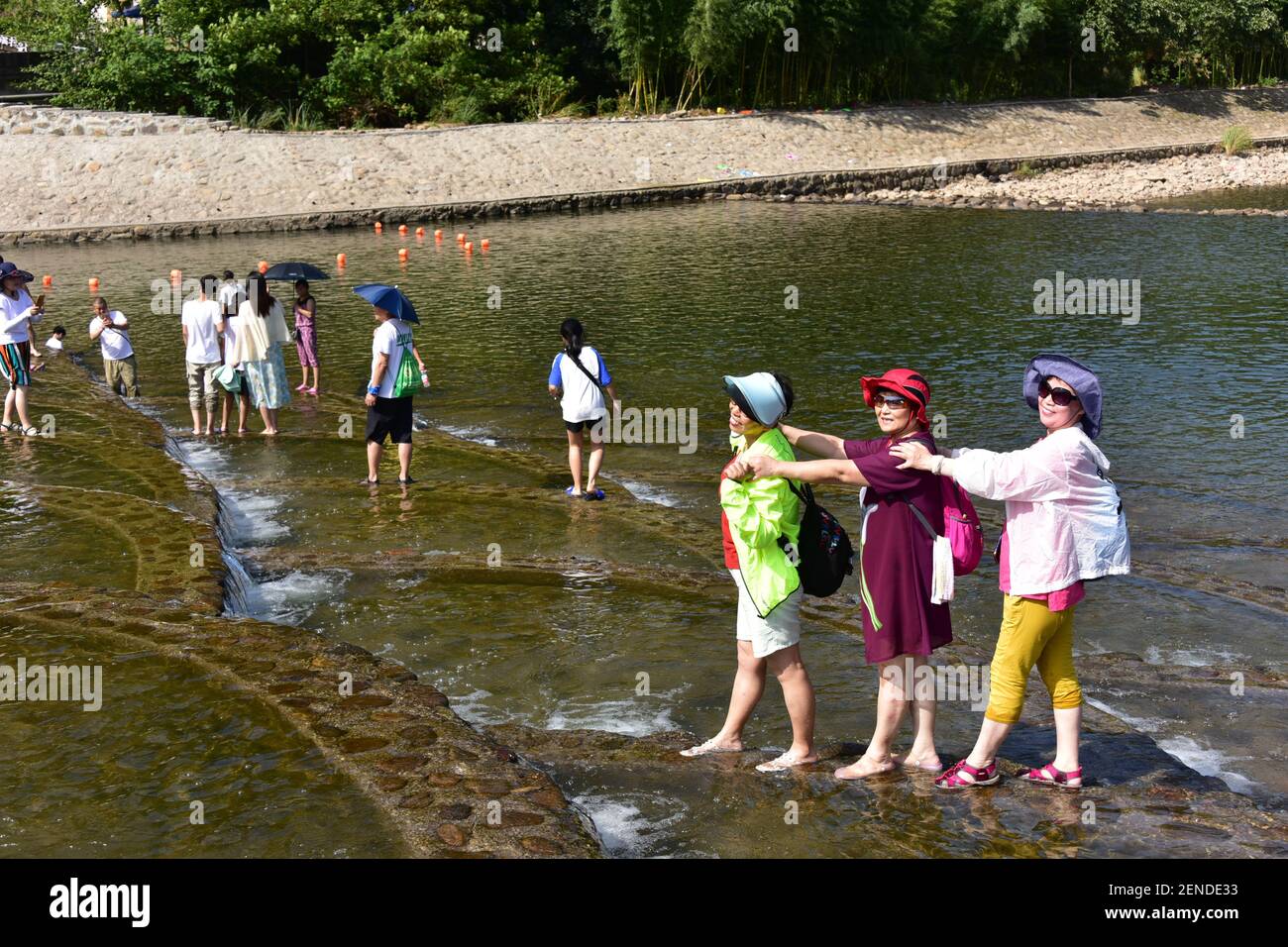 Visitors take a dip to cool off in water in a location known for fish ...