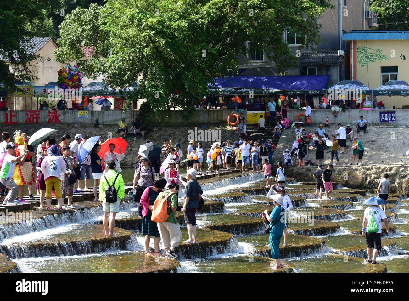 Visitors take a dip to cool off in water in a location known for fish ...