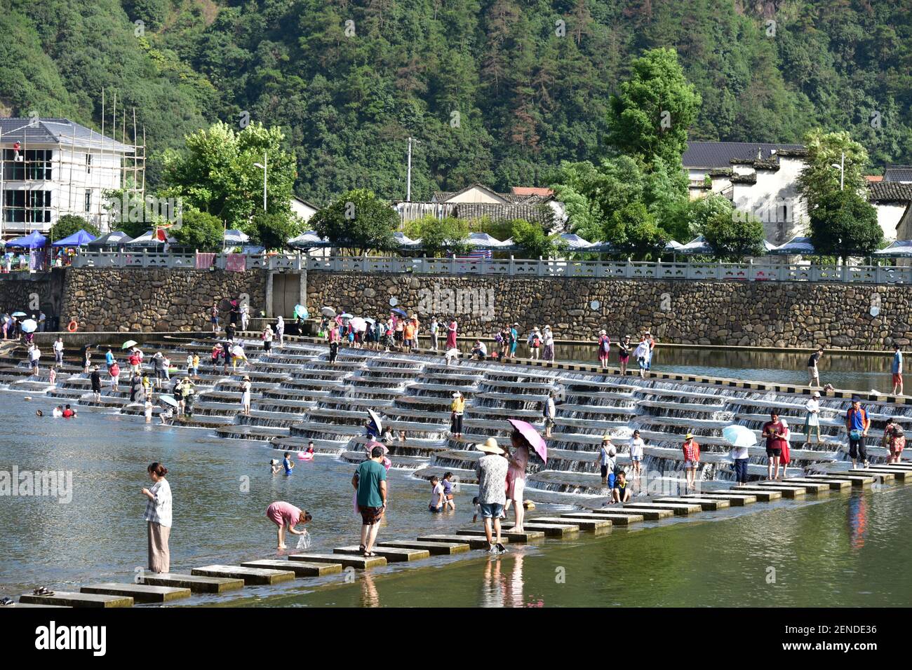 Visitors take a dip to cool off in water in a location known for fish ...