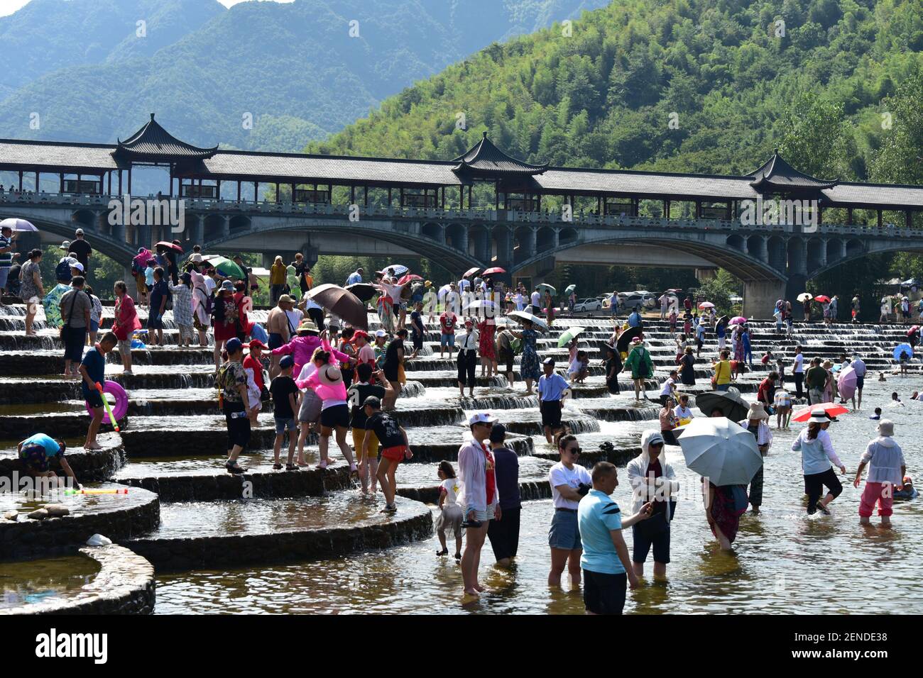 Visitors take a dip to cool off in water in a location known for fish ...