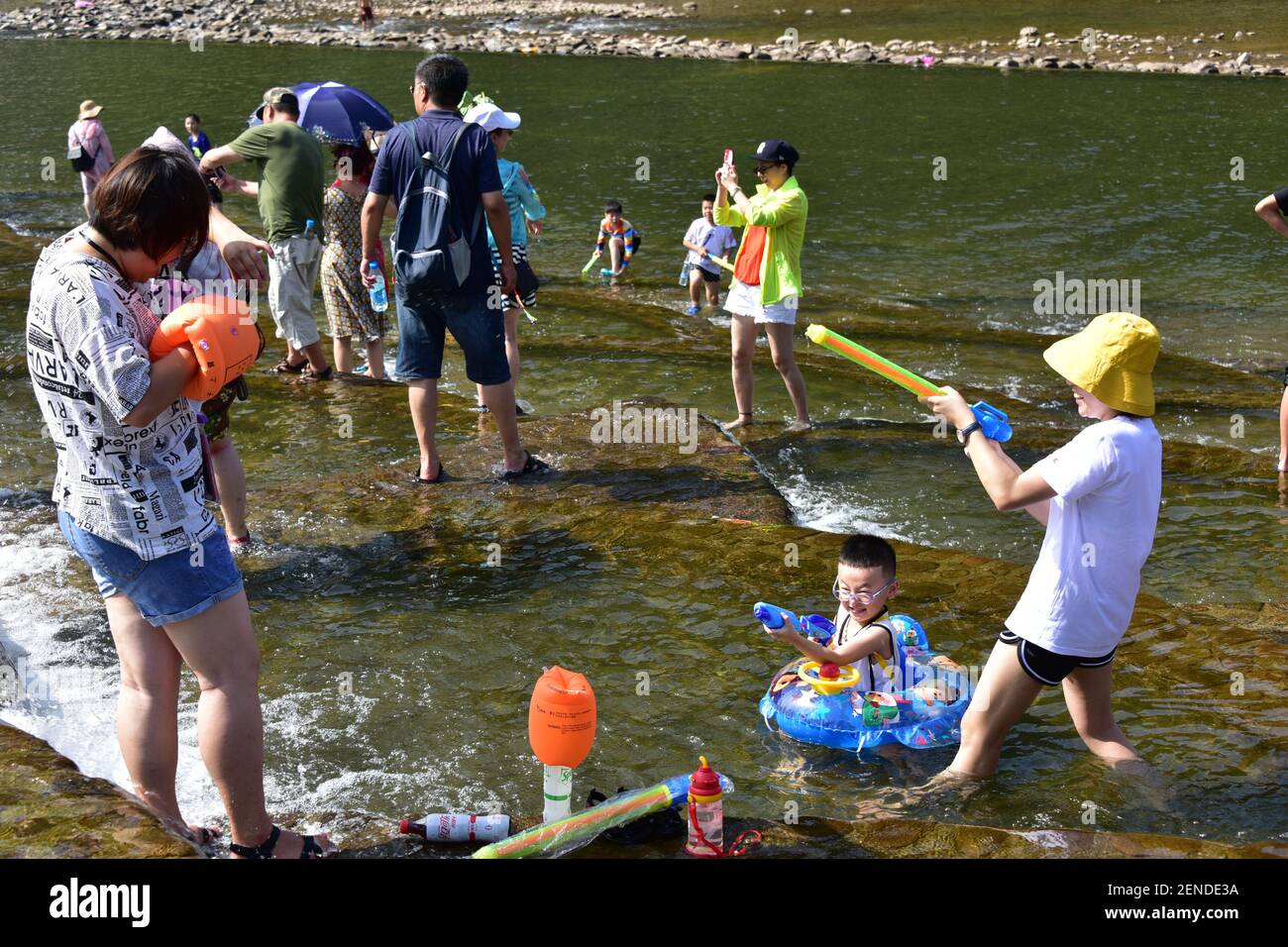 Visitors take a dip to cool off in water in a location known for fish ...