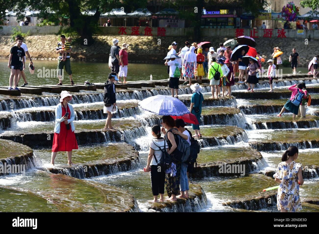 Visitors take a dip to cool off in water in a location known for fish ...