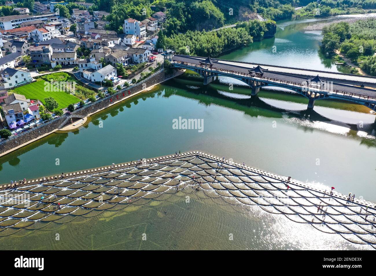 Visitors take a dip to cool off in water in a location known for fish ...