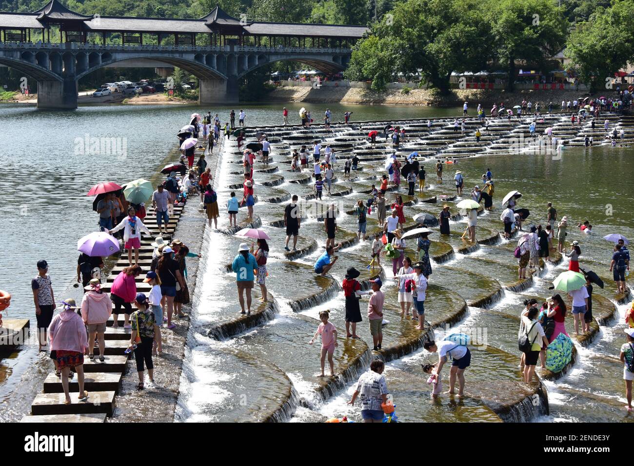 Visitors take a dip to cool off in water in a location known for fish ...