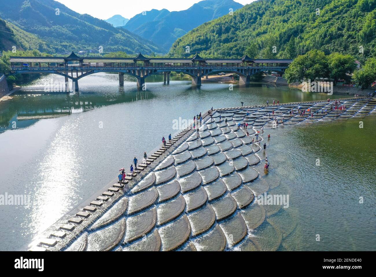 Visitors take a dip to cool off in water in a location known for fish ...