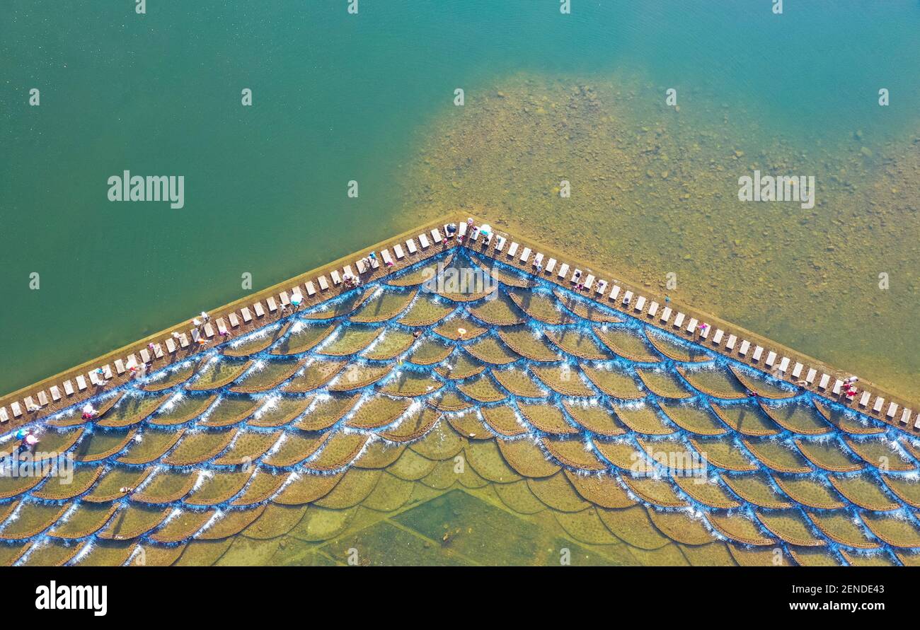 Visitors take a dip to cool off in water in a location known for fish ...