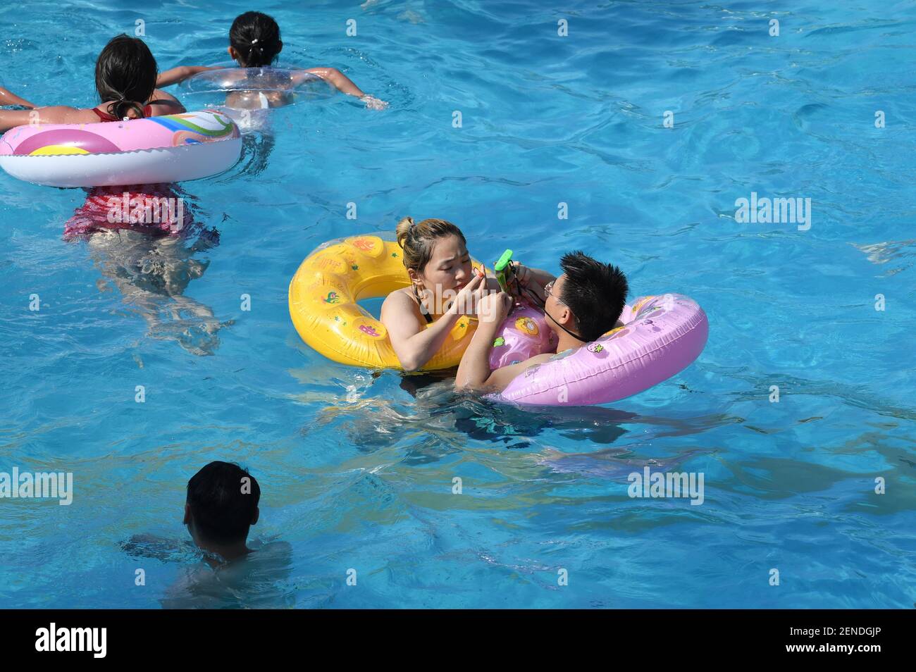 Chinese holidaymakers crowd a swimming pool at a water park to escape ...
