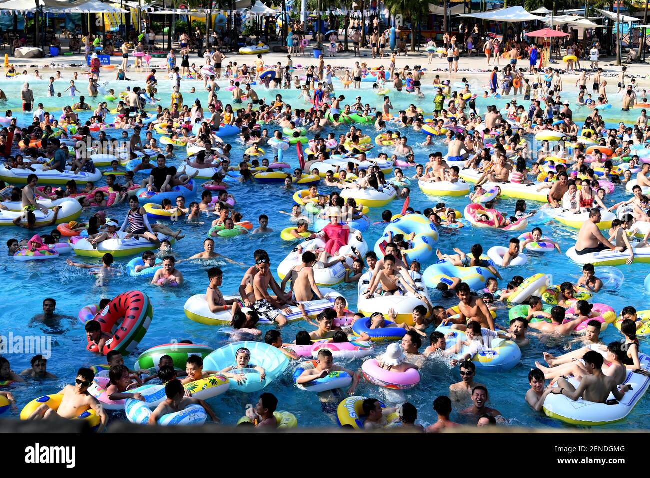 Chinese holidaymakers crowd a swimming pool at a water park to escape ...