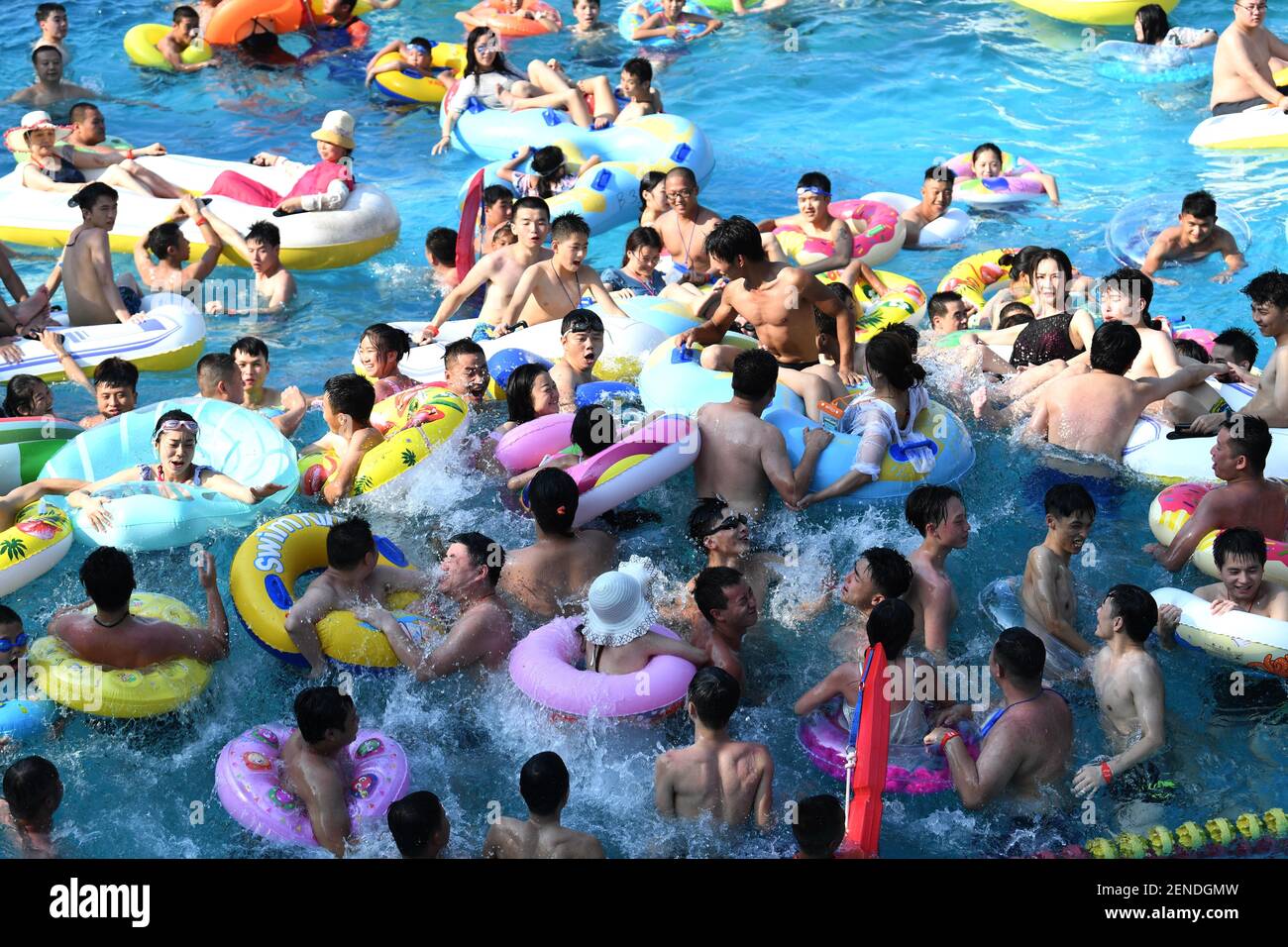 Chinese holidaymakers crowd a swimming pool at a water park to escape ...