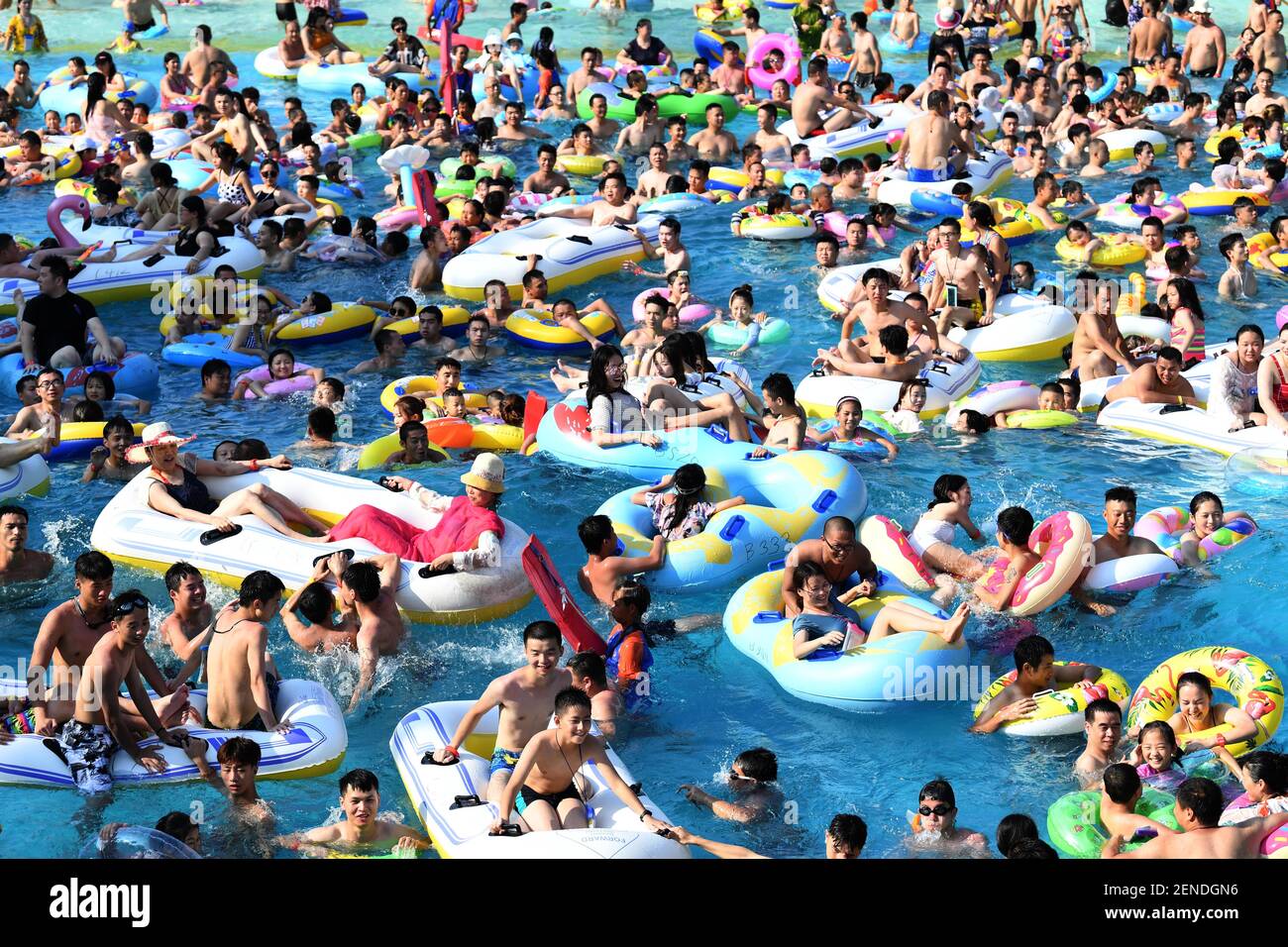 Chinese holidaymakers crowd a swimming pool at a water park to escape ...