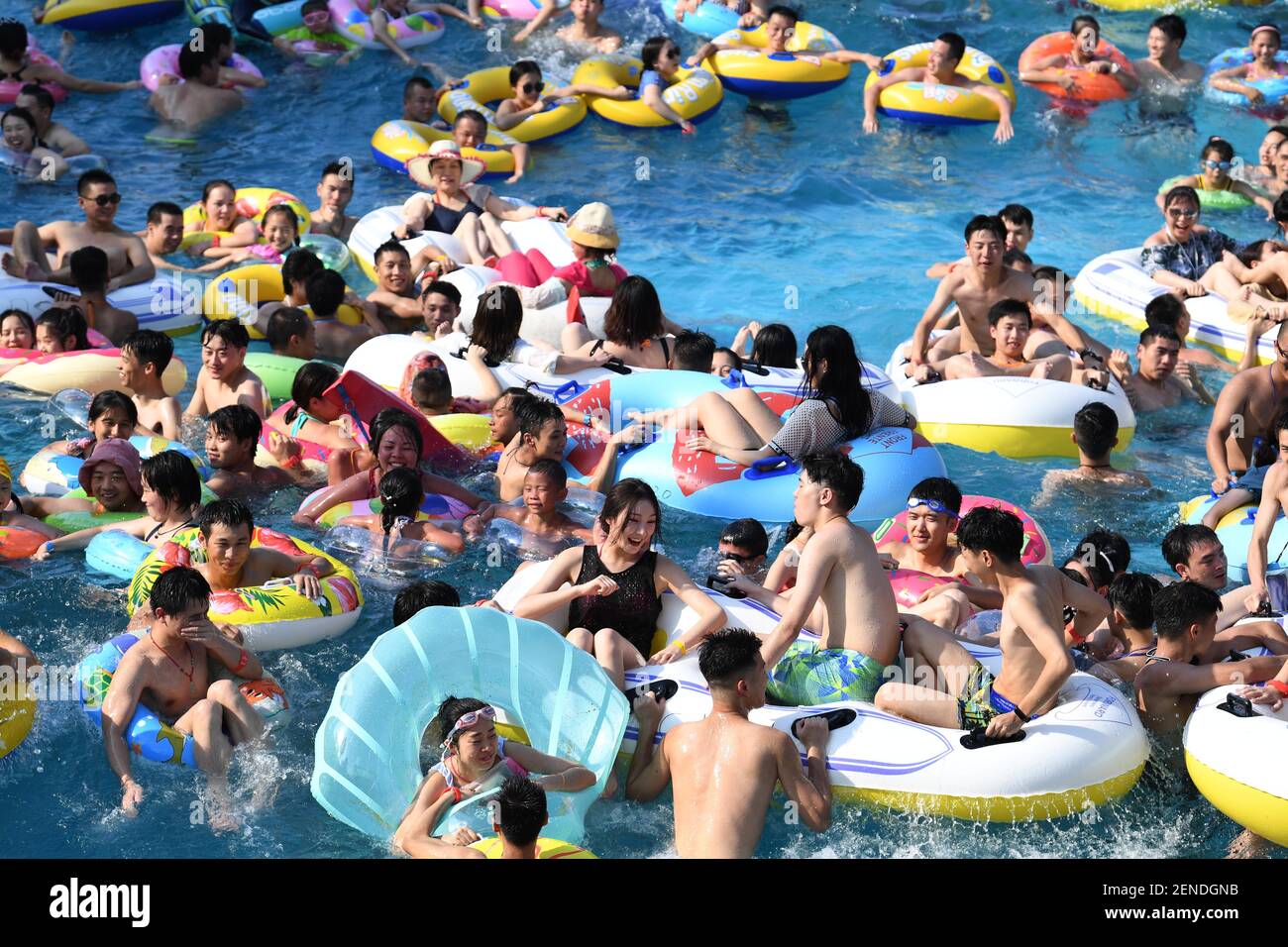 Chinese holidaymakers crowd a swimming pool at a water park to escape ...