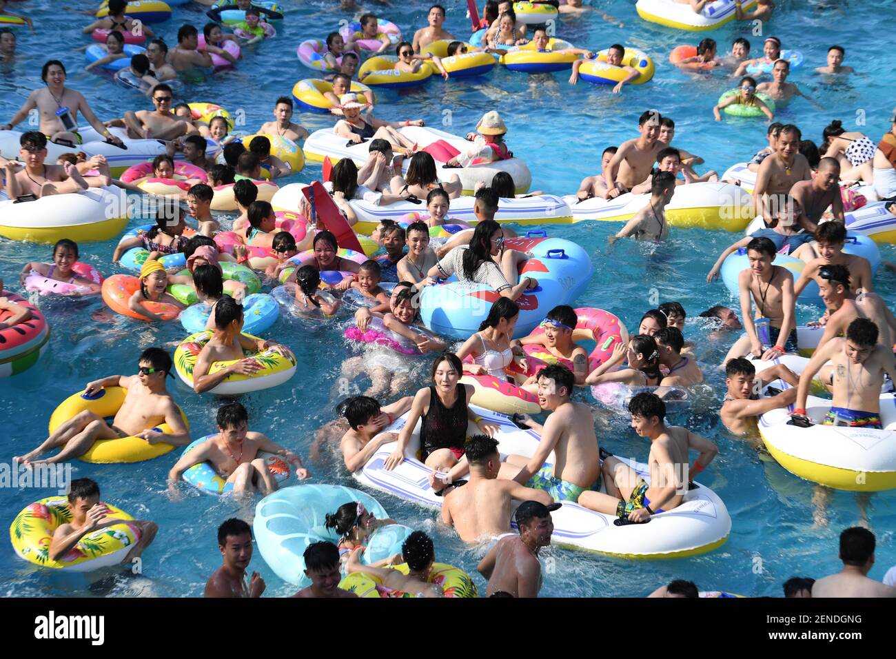 Chinese holidaymakers crowd a swimming pool at a water park to escape ...