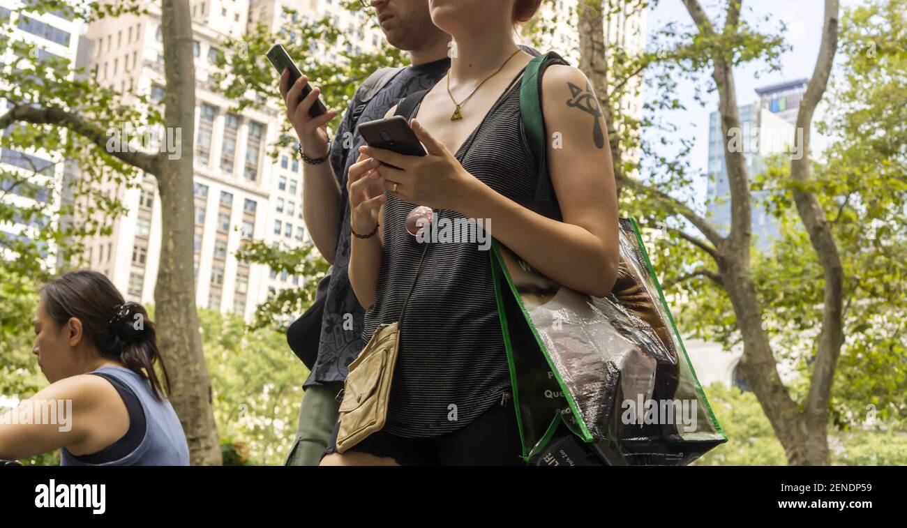 Distracted millennials, engrossed in their smartphones, in Bryant Park in New York on Thursday ...