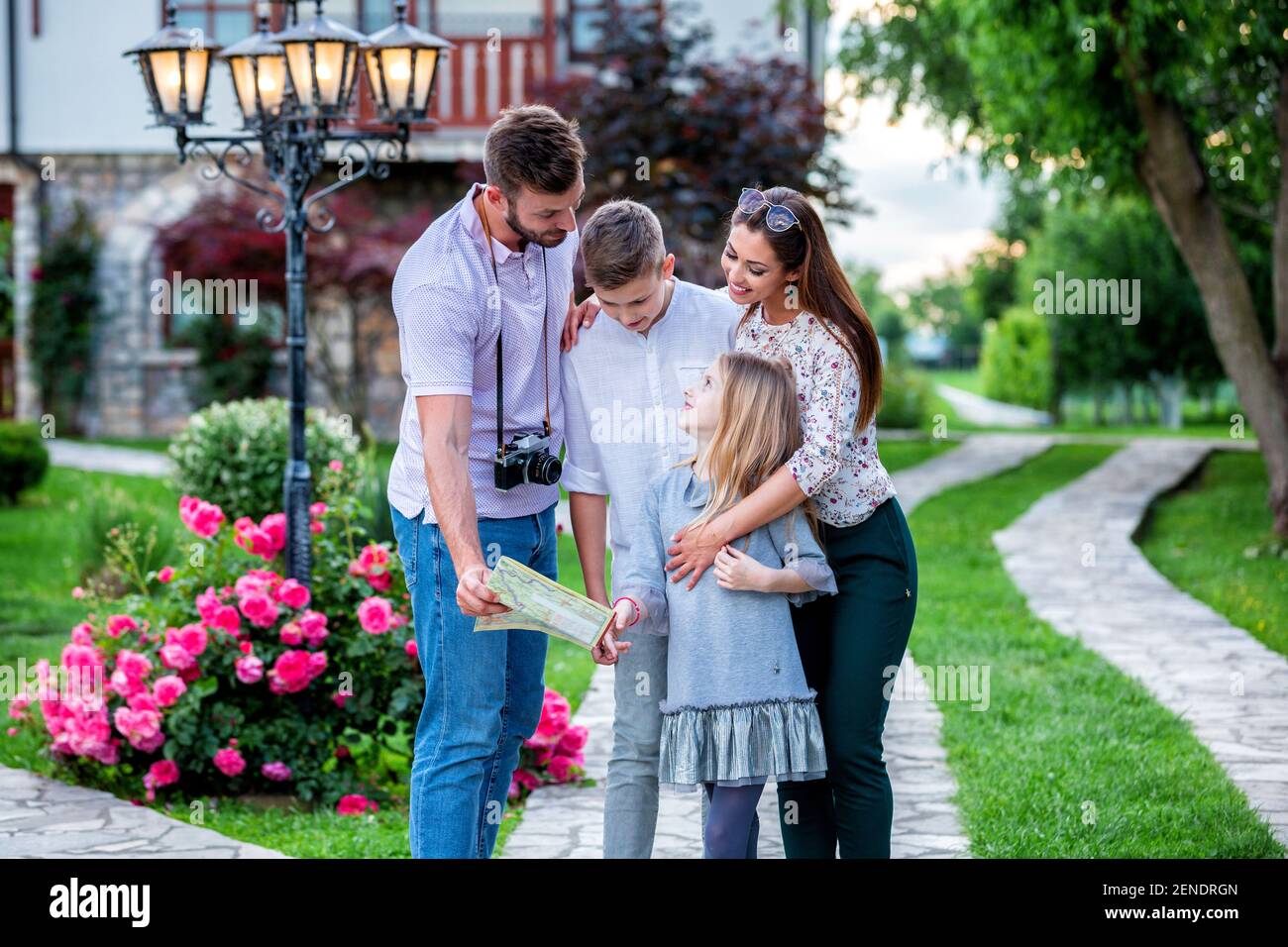 Lucky family members studying a map, while talking a walk Stock Photo ...