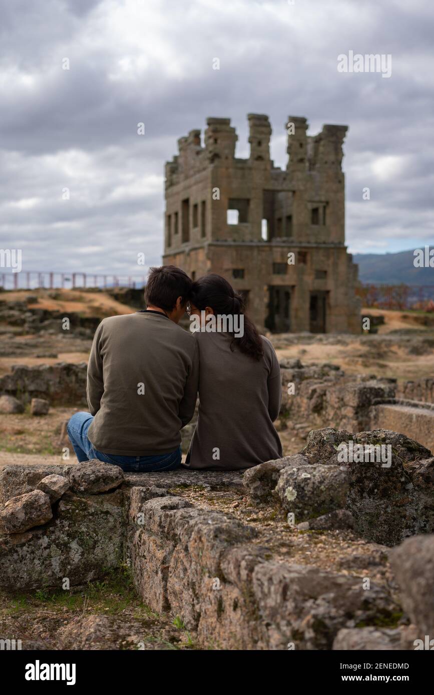 Couple sit looking at roman ruins of Centum Cellas in Belmonte ...