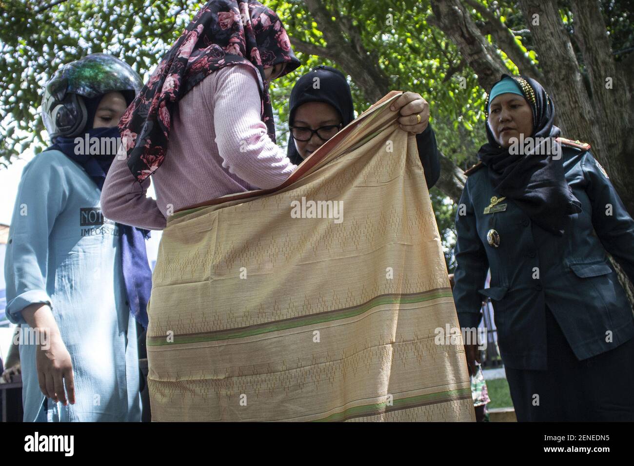 Sharia police officers dress a woman during the enforcement. Dozens of ...