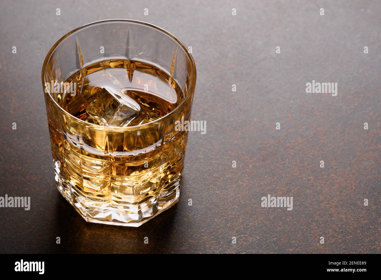 Glass of cold whiskey on dark brown background. Close up Stock Photo ...