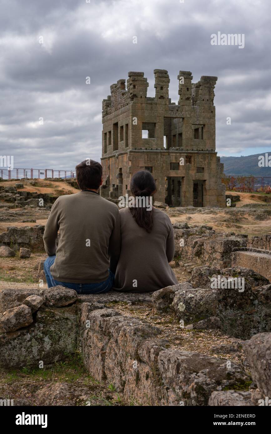 Couple sit looking at roman ruins of Centum Cellas in Belmonte ...