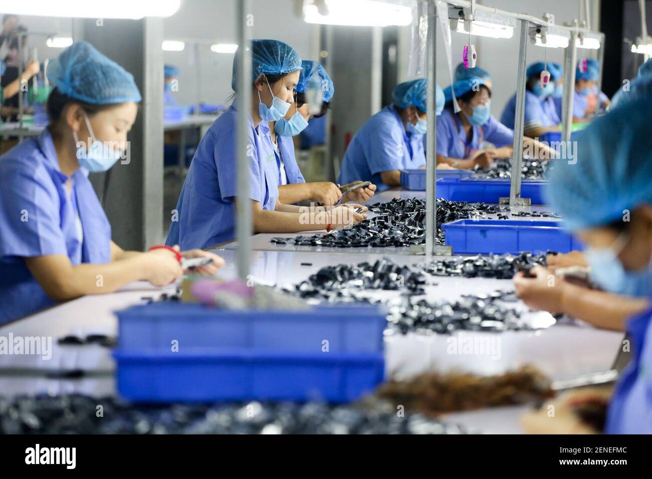 Chinese female workers manufacture makeup brushes on an assembly line ...