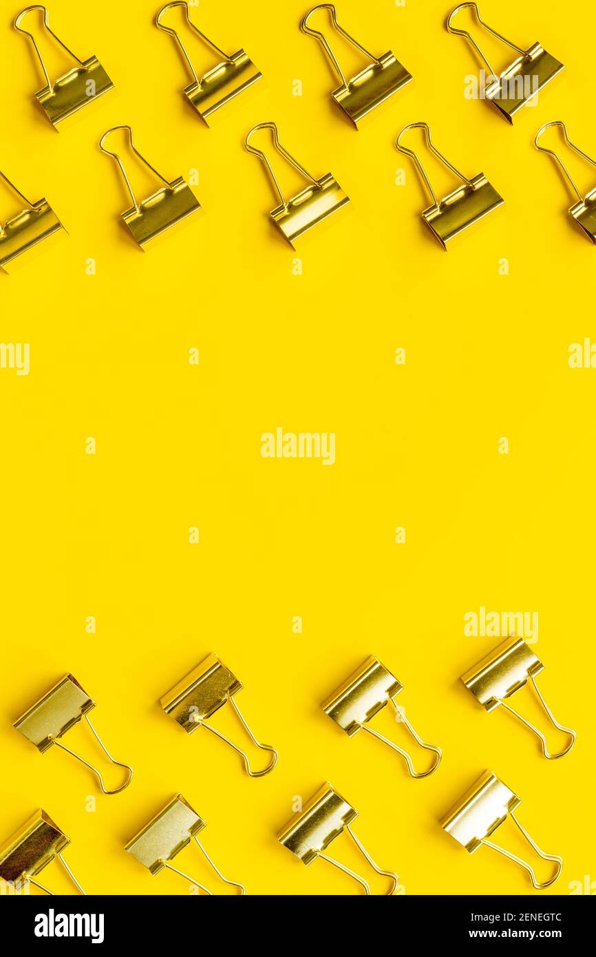 Frame of stationery golden paper binder clips top view. Office supplies ...