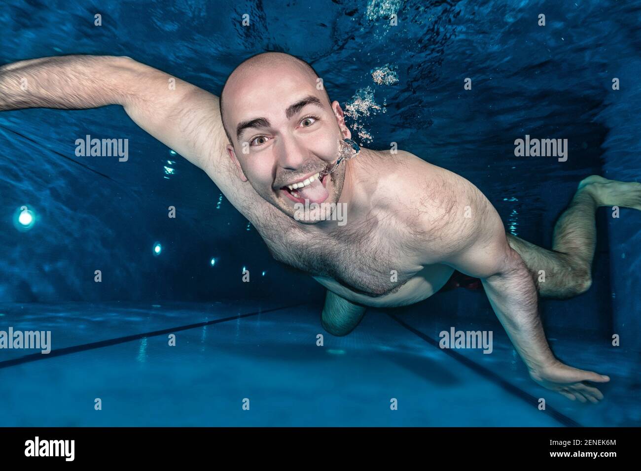 Funny guy goofing around while diving and making funny faces underwater ...