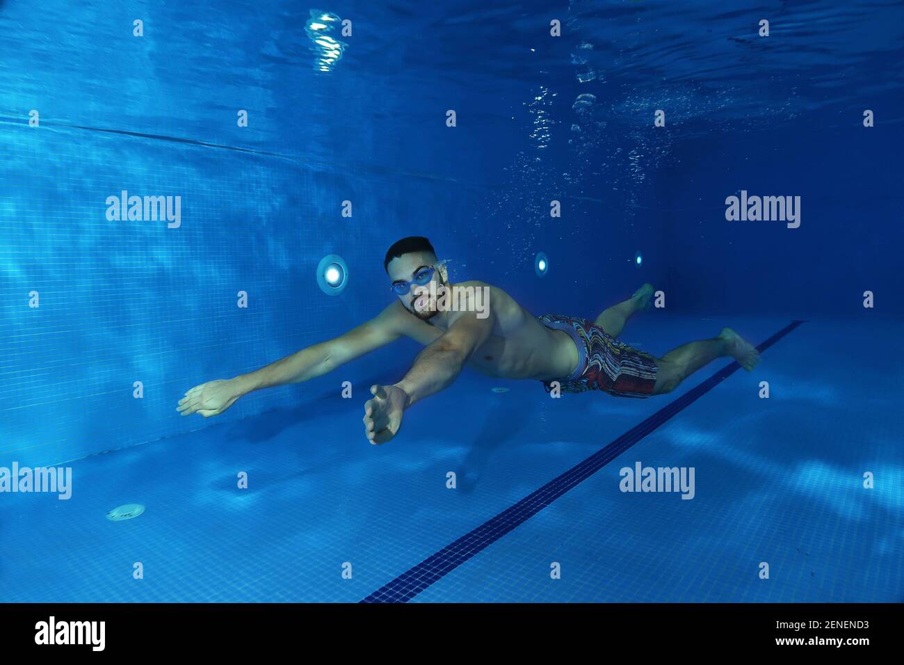 Underwater image of a young man swimming submerged in the swimming pool ...