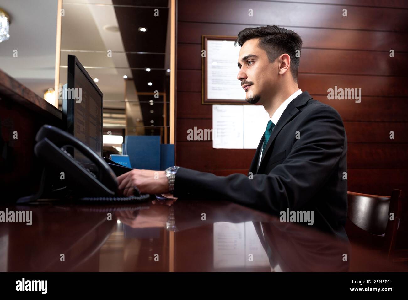 Hotel receptionist upholding his responsibilities and managing guests ...