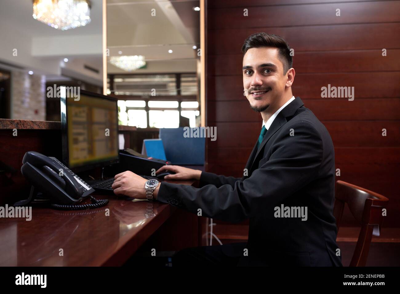 Receptionist sitting behind reception desk hi-res stock photography and ...