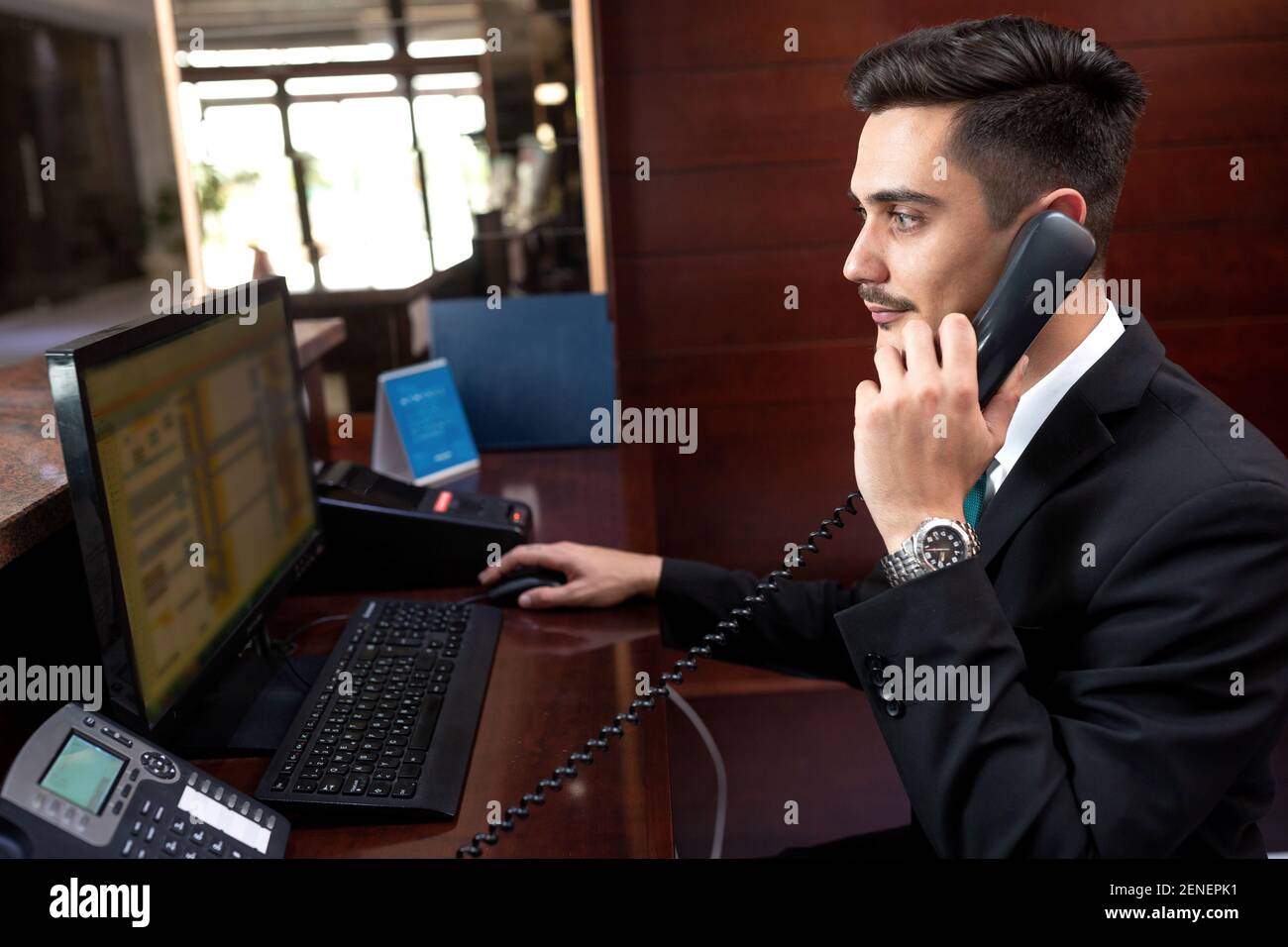 Receptionist sitting behind reception desk hi-res stock photography and ...