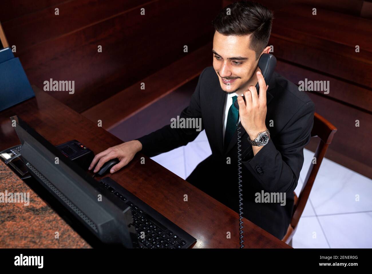 Hotel receptionist busy at work, hotel management concept Stock Photo ...