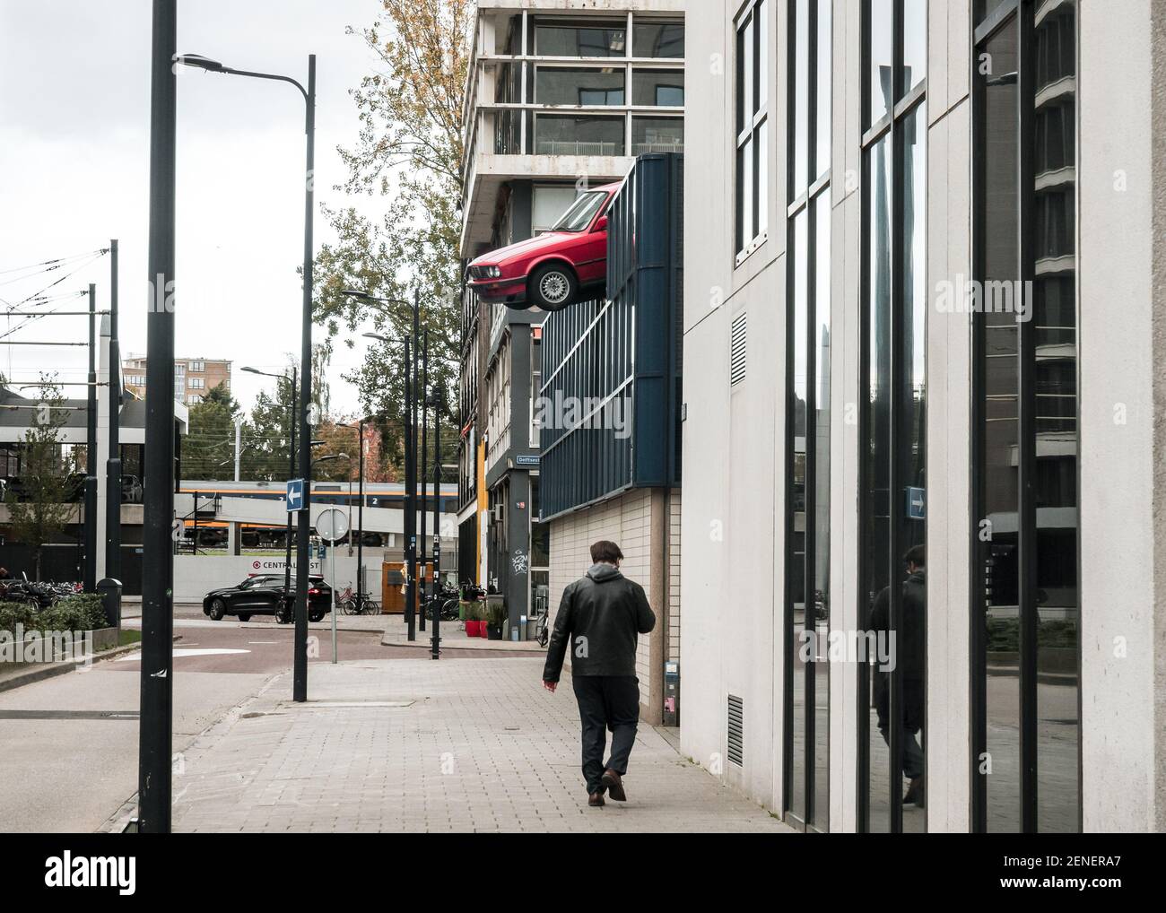 Red car crashing through top story of multi storey car park hanging ...