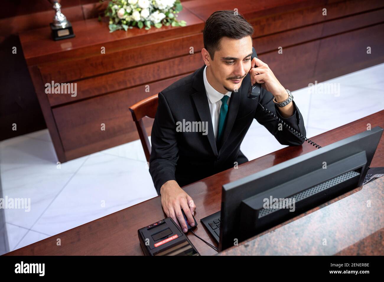 Receptionist sitting behind reception desk hi-res stock photography and ...