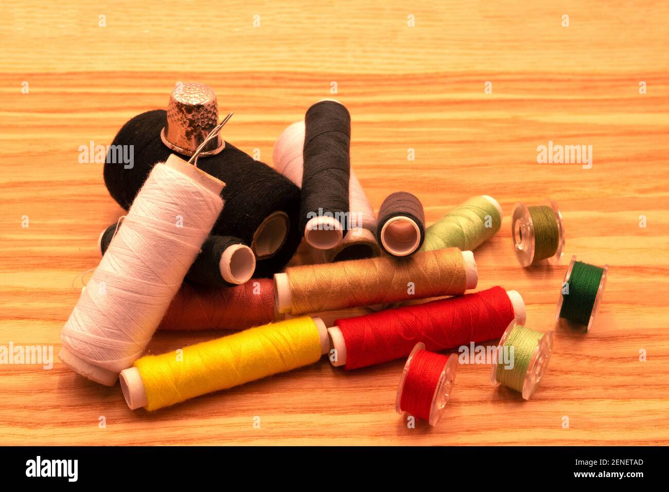 Photograph of sewing threads on light wooden background Stock Photo - Alamy