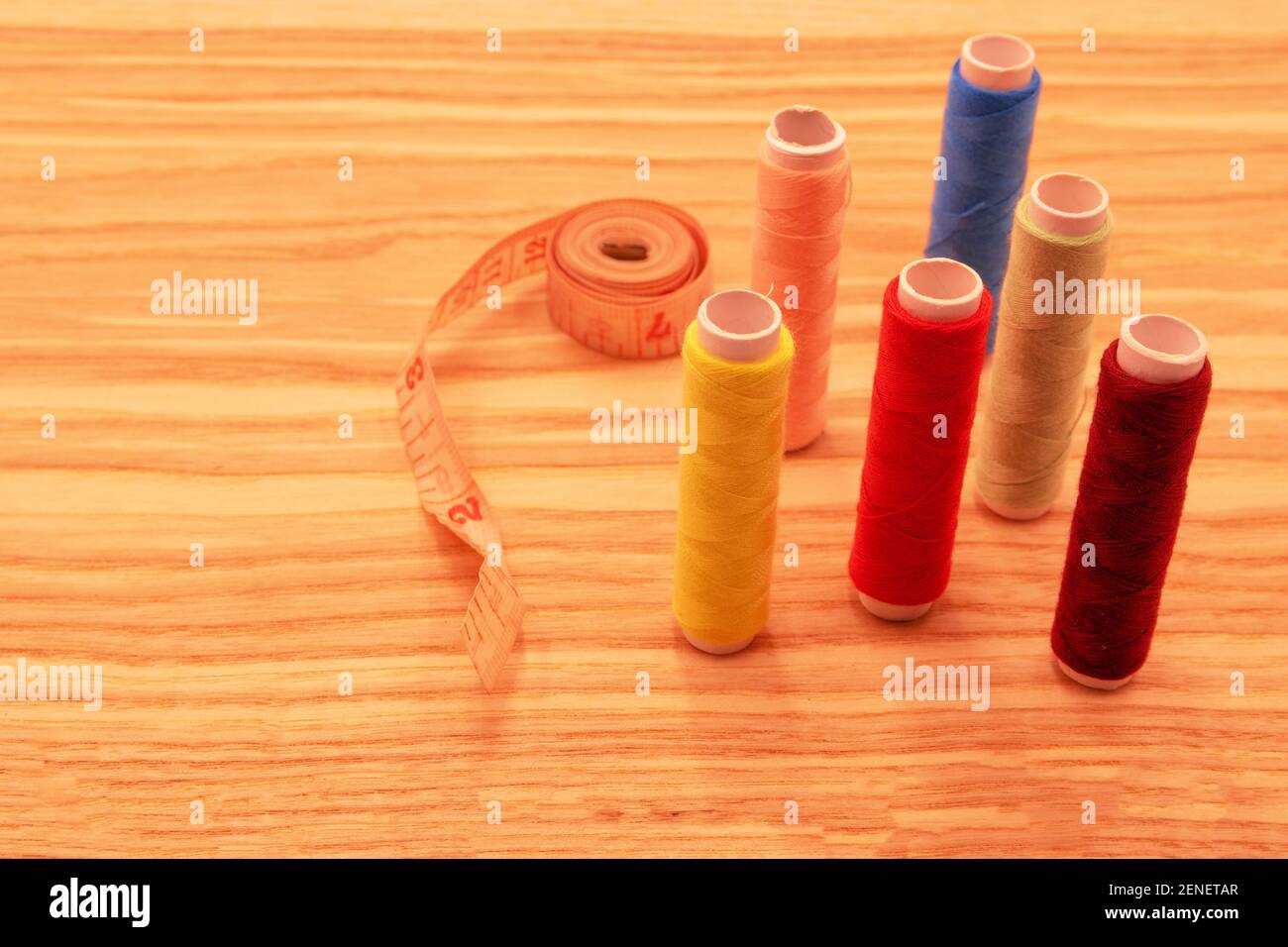photography of sewing threads of various colors and sewing tools on ...