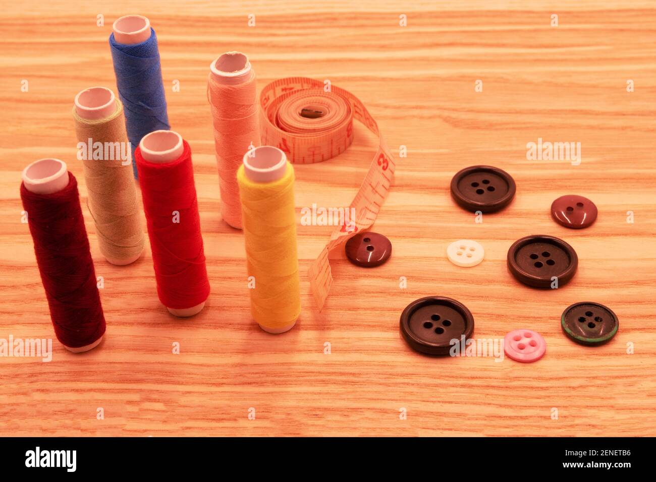 Photograph of multi-colored sewing threads and sewing tools on light ...