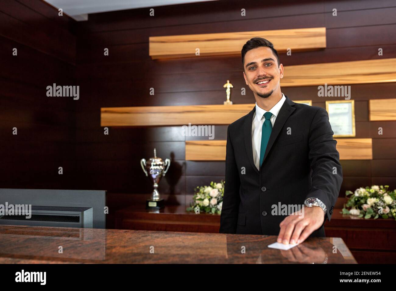 Hotel receptionist offering a key card, guest management system Stock ...