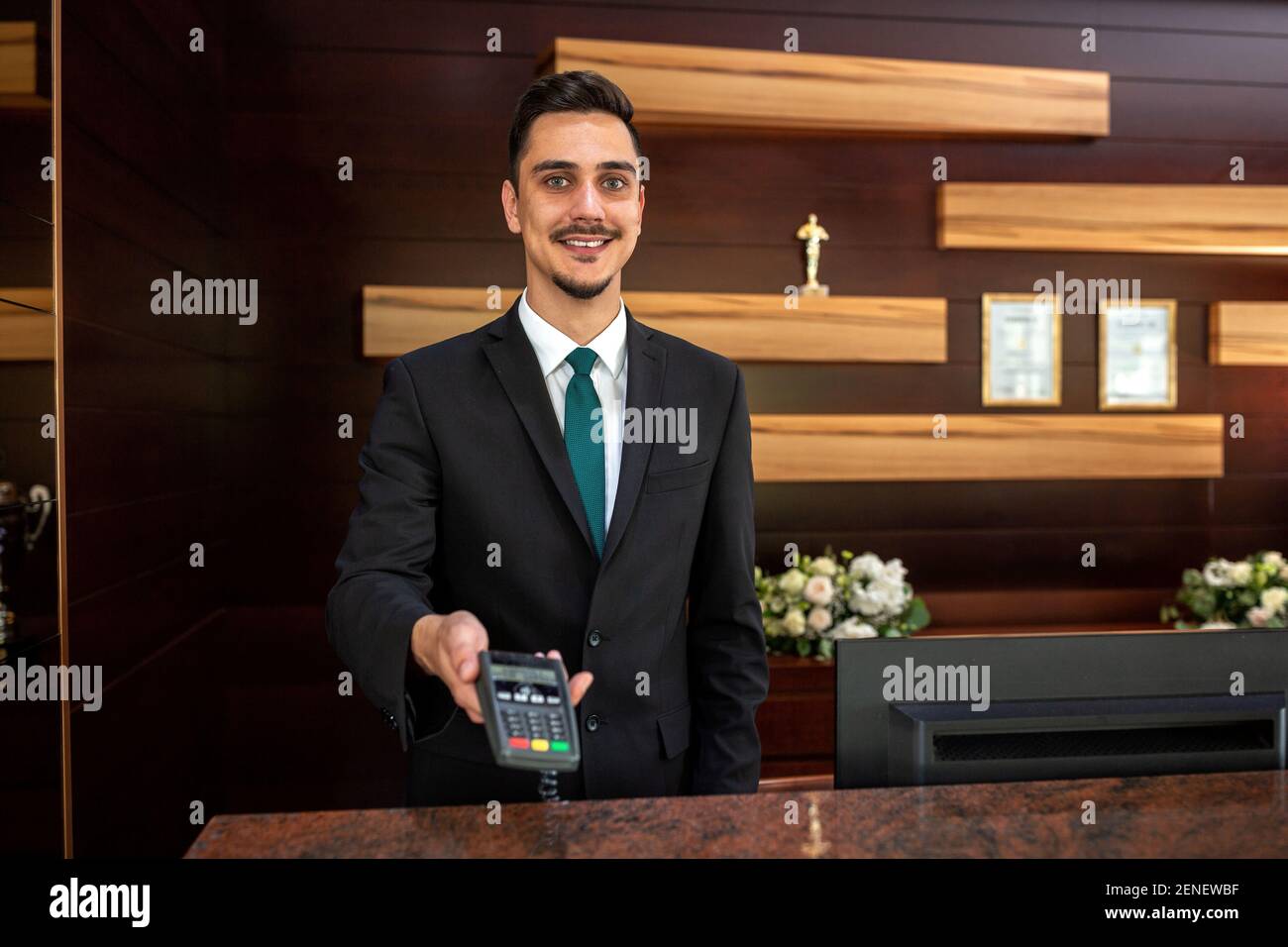 Credit card reader at a hotel reception desk held by receptionist Stock ...