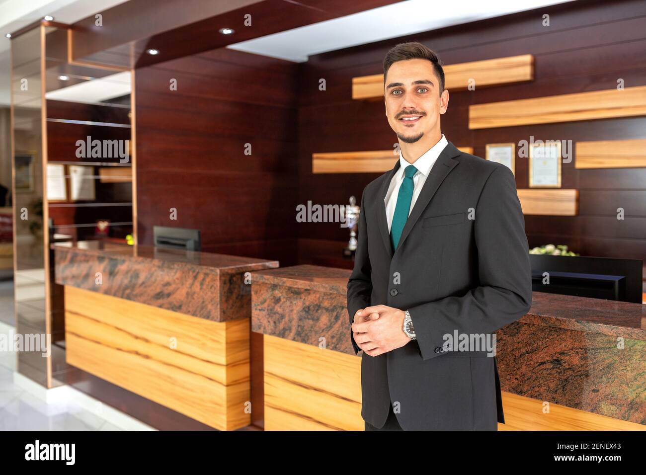 Receptionist dressed in fancy suit standing and welcoming guests Stock ...